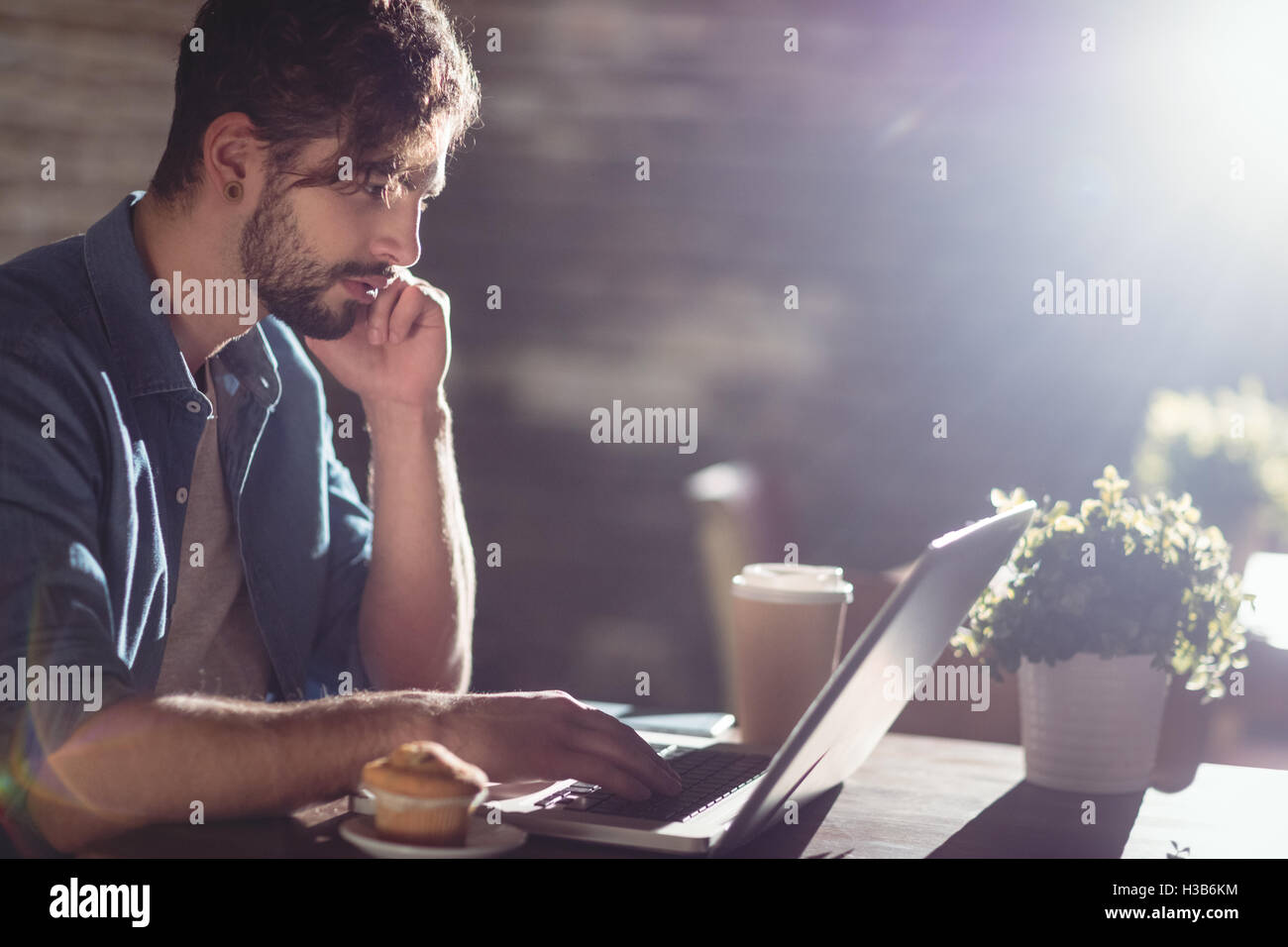 Side view of man concentrating on laptop at cafe Stock Photo - Alamy