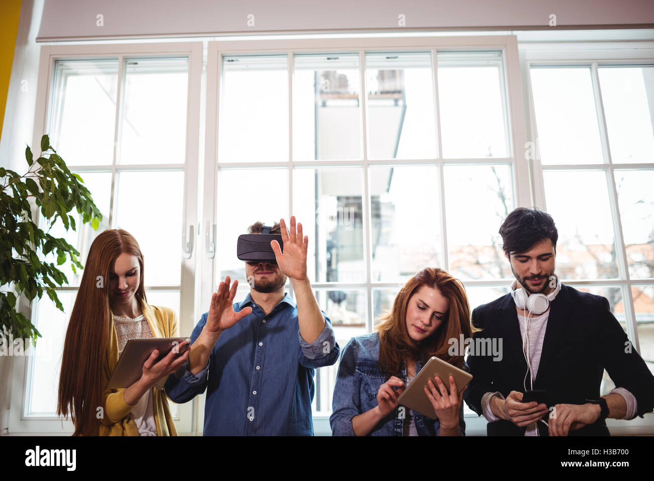 Business people using electronic devices in meeting room Stock Photo ...