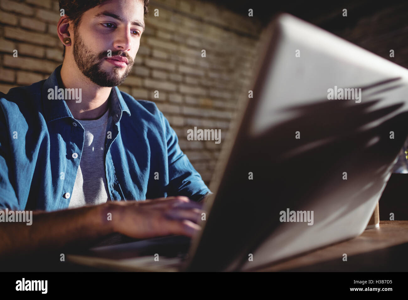 Handsome man concentrating on laptop at coffee shop Stock Photo - Alamy