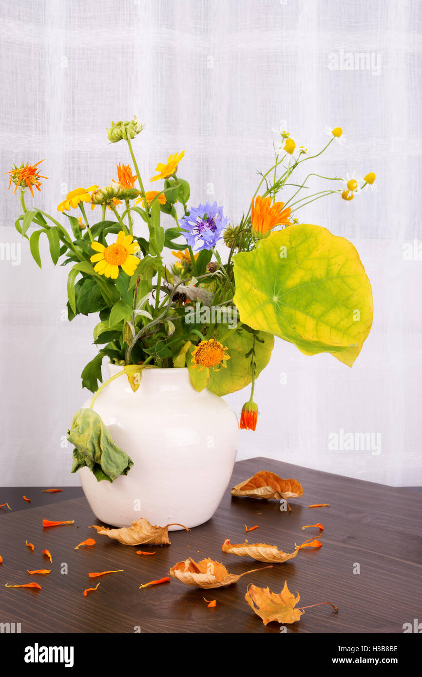 Bright rustic bouquet of withering flowers in a ceramic vase, dried ...
