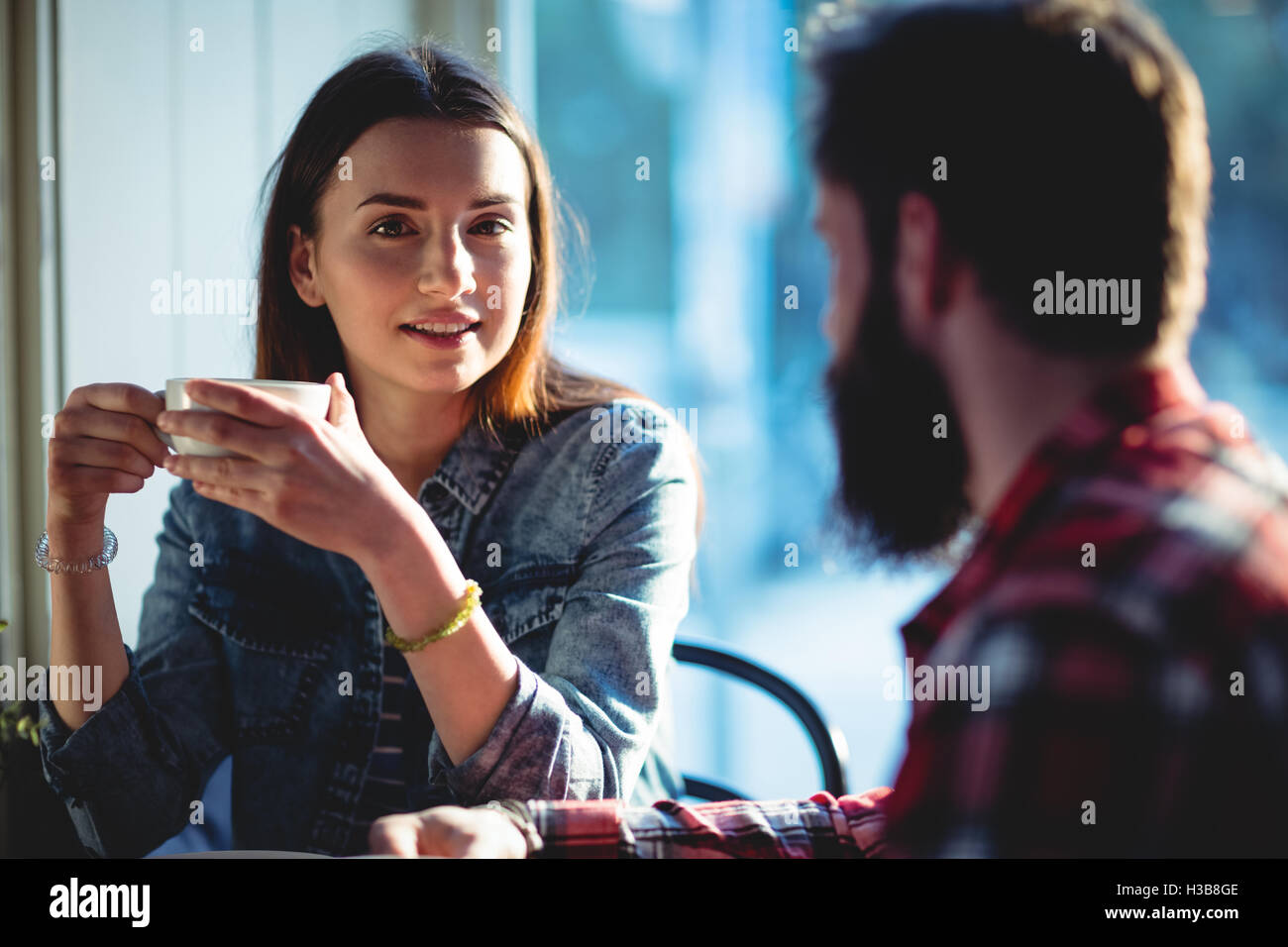 Young woman talking to boyfriend at cafe Stock Photo - Alamy