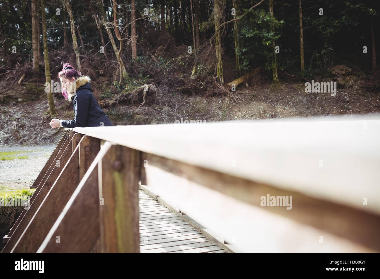 Young woman leaning against bridge Stock Photo - Alamy