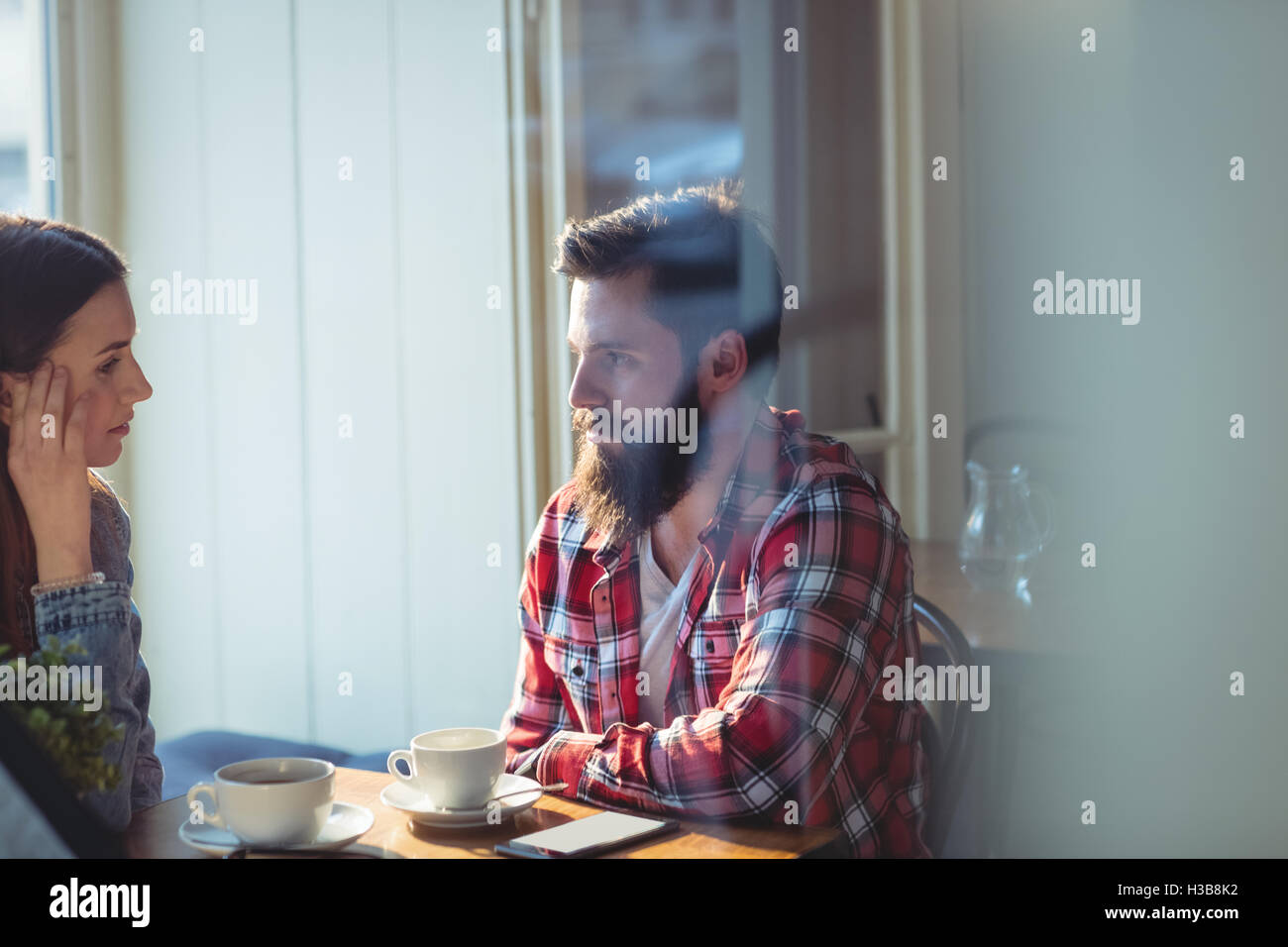 Young couple talking at cafe Stock Photo - Alamy