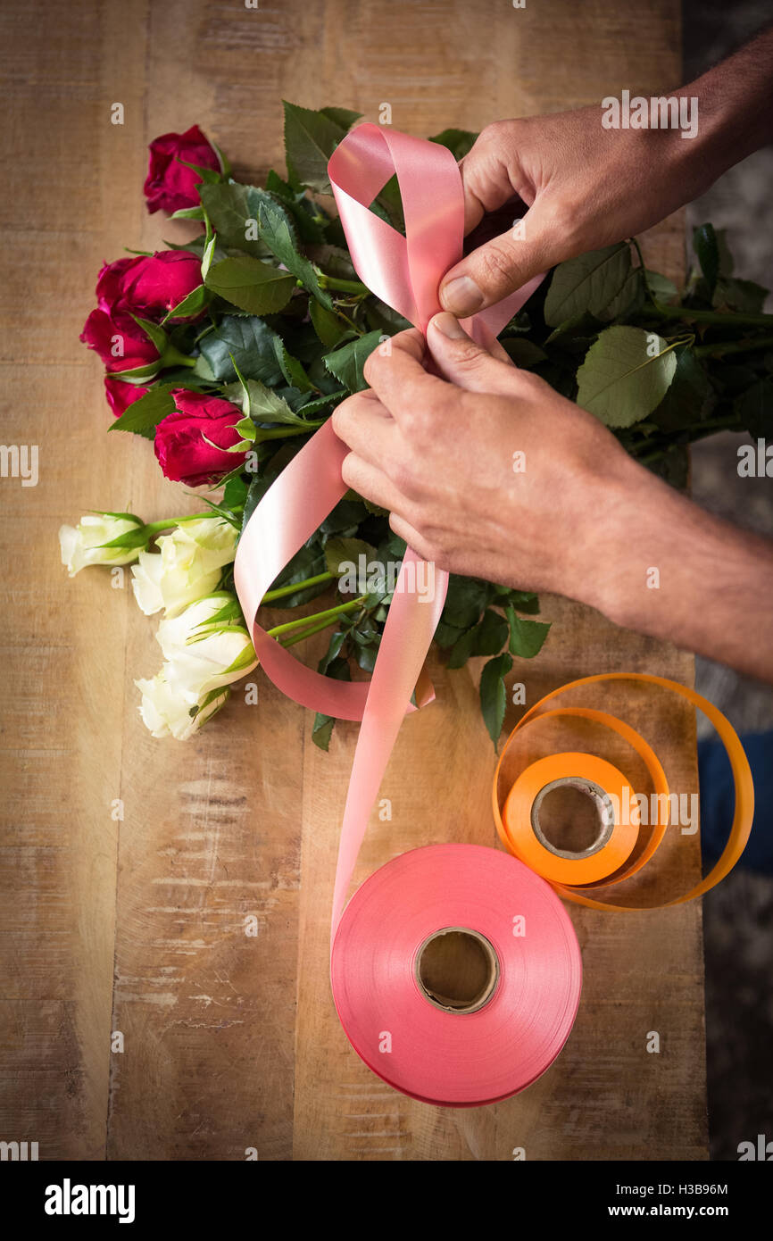 Male florist tying poly ribbon on bouquet of flower Stock Photo - Alamy