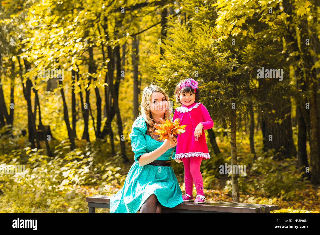 Young mother playing with her daughter in autumn park Stock Photo - Alamy