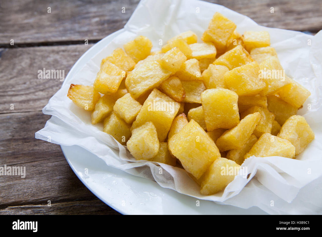 portions of fried potatoes on white paper ready for eat Stock Photo - Alamy