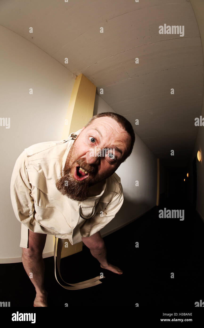 Photo of an insane man in his forties wearing a straitjacket standing ...