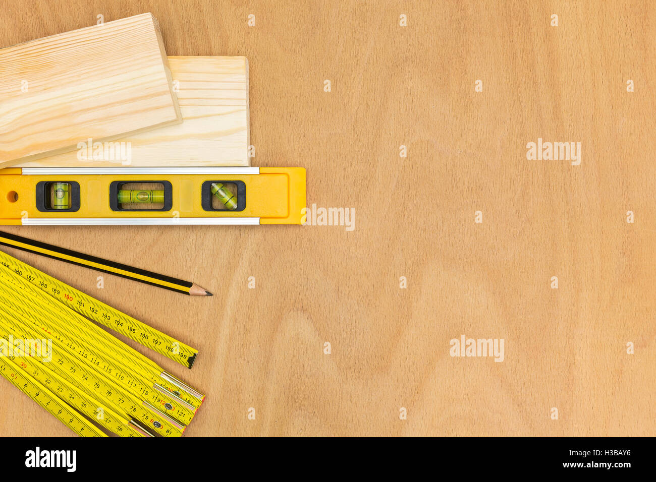 Folding rule, bubble level and pencil on wooden background Stock Photo ...