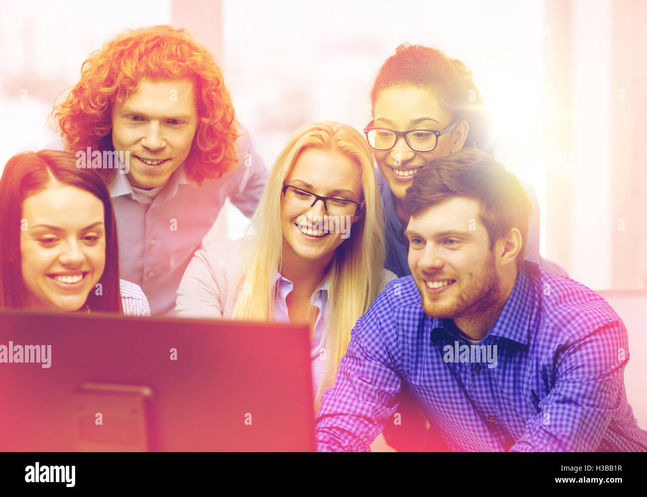 smiling business team looking at computer monitor Stock Photo - Alamy