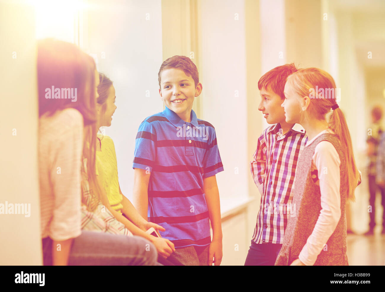 group of smiling school kids talking in corridor Stock Photo - Alamy