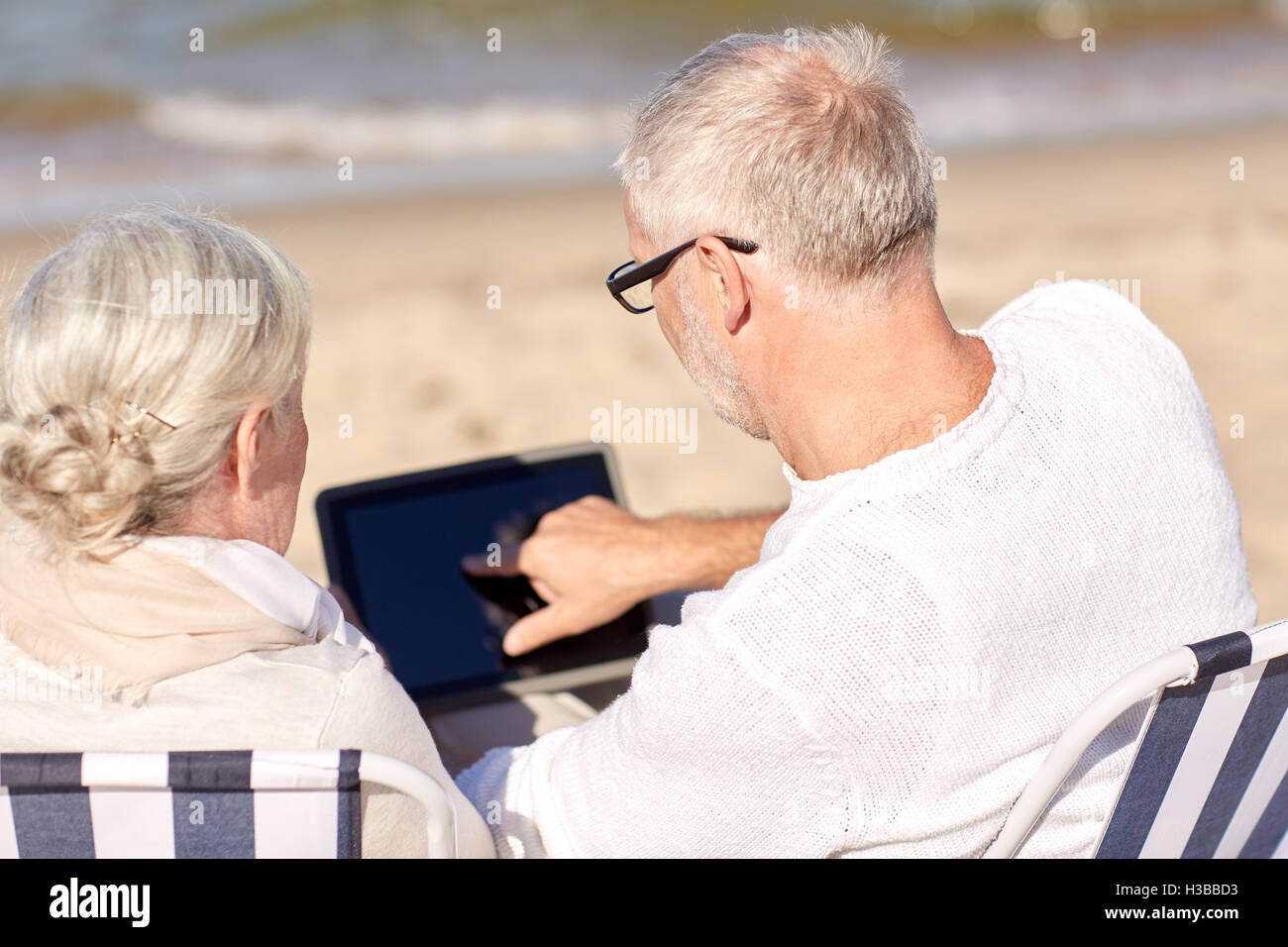 Couple on beach browsing hi-res stock photography and images - Alamy