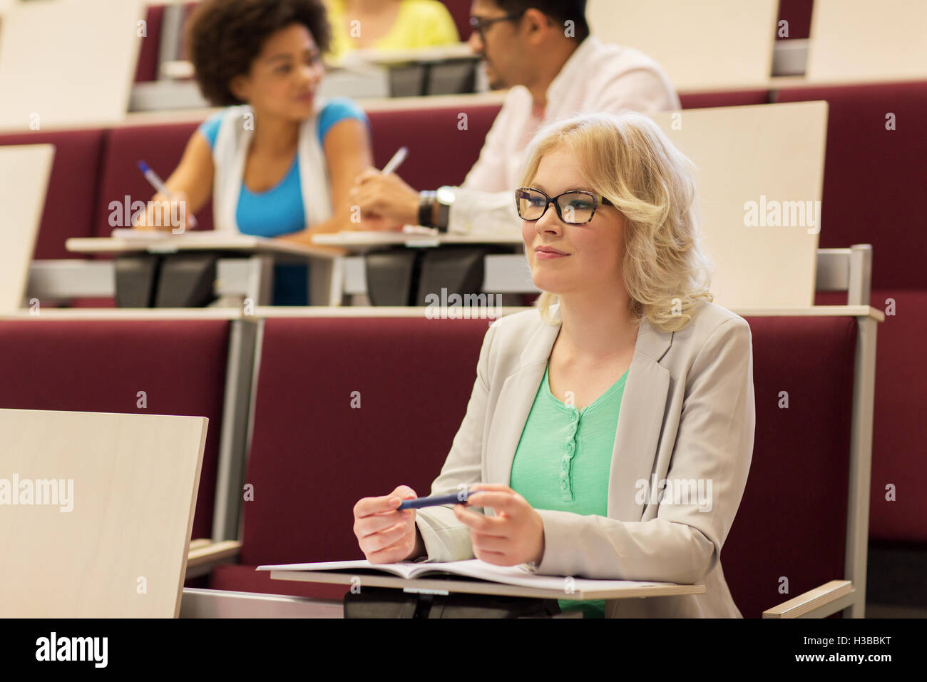 student girl writing to notebook in lecture hall Stock Photo - Alamy