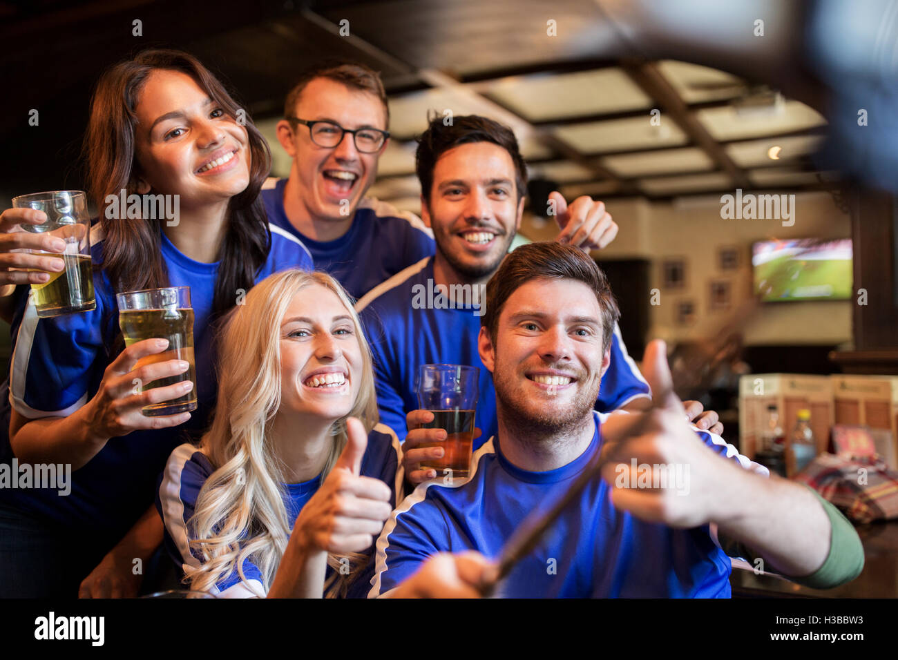 football fans with beer taking selfie at pub Stock Photo - Alamy