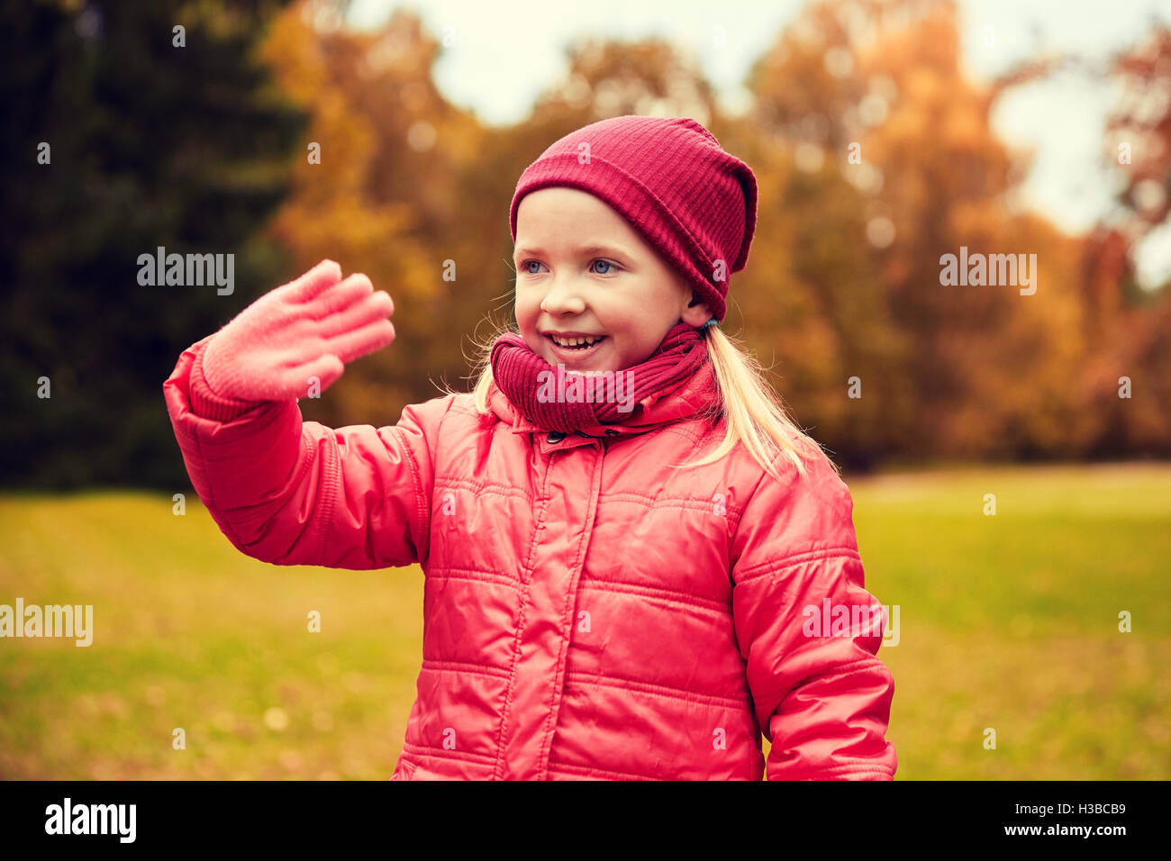 happy little girl waving hand in autumn park Stock Photo - Alamy