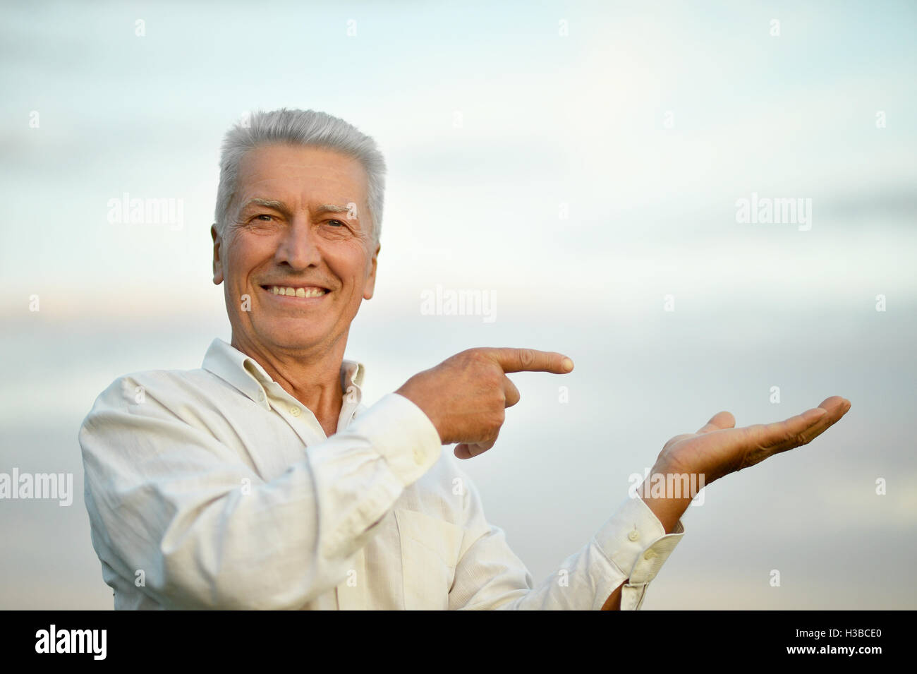 senior man pointing on sky background Stock Photo - Alamy