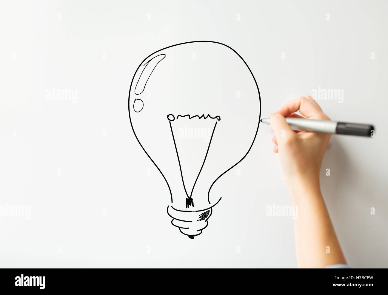close up of hand drawing light bulb on white board Stock Photo - Alamy