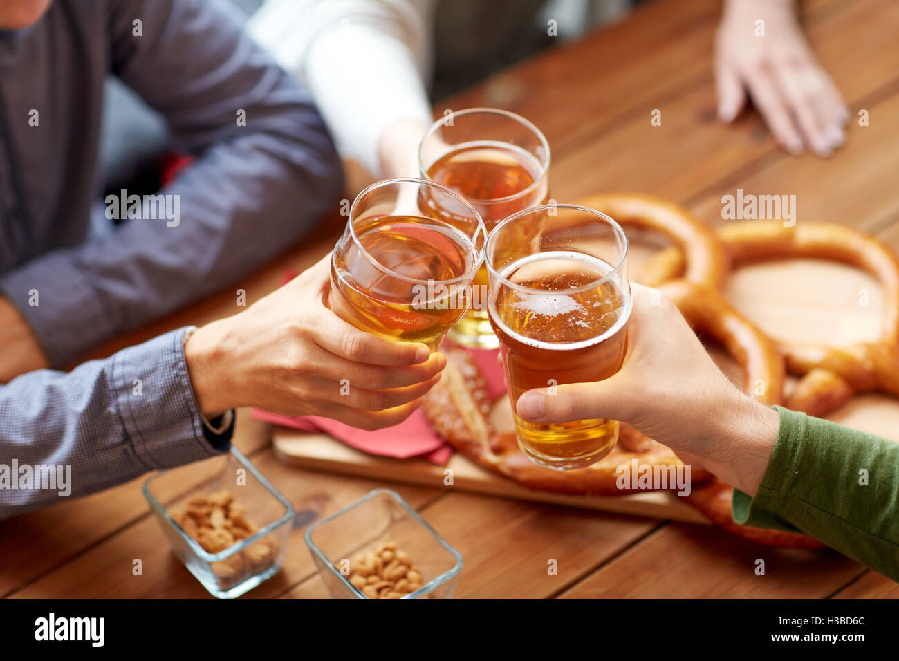 close up of hands clinking beer at bar or pub Stock Photo - Alamy