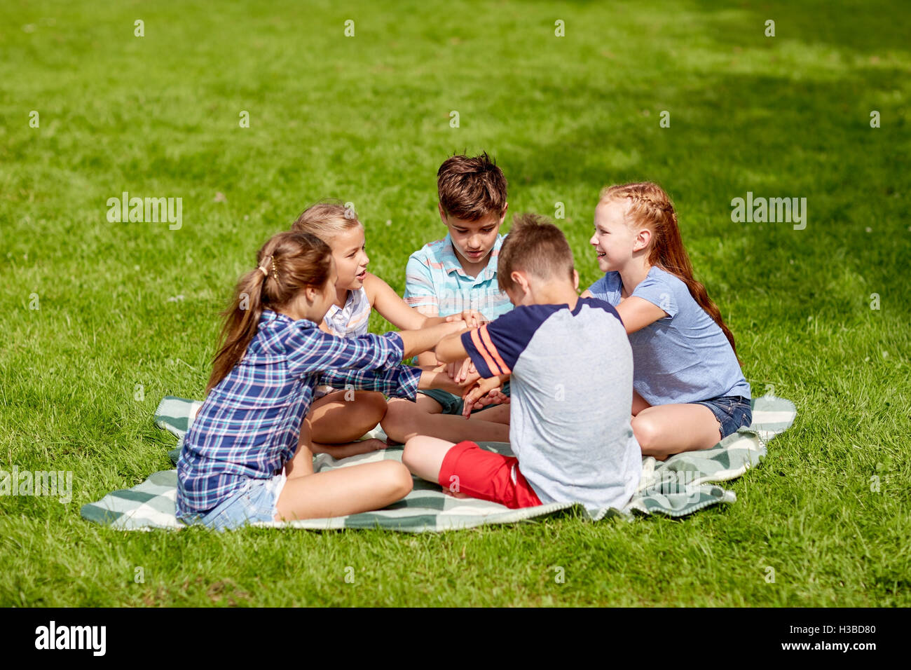 group of happy kids putting hands together Stock Photo - Alamy