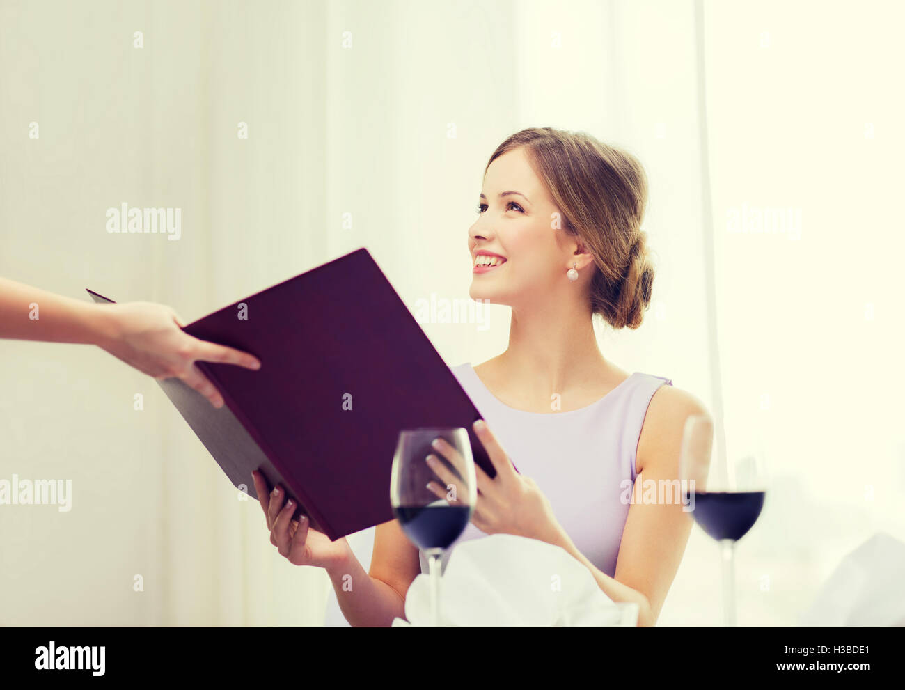 smiling woman recieving menu from waiter Stock Photo - Alamy