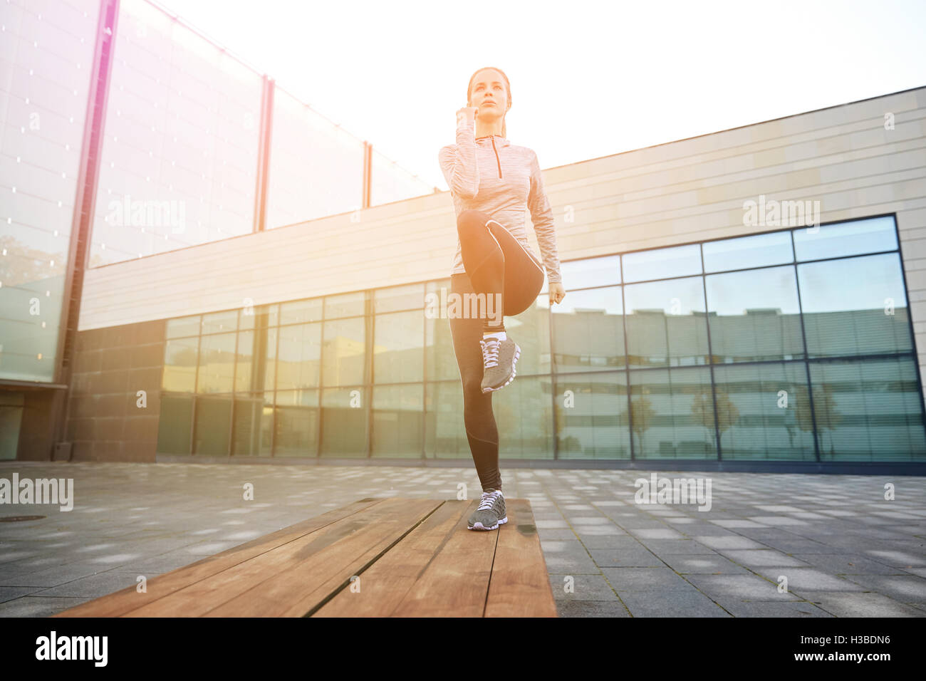 woman making step exercise on city street bench Stock Photo - Alamy