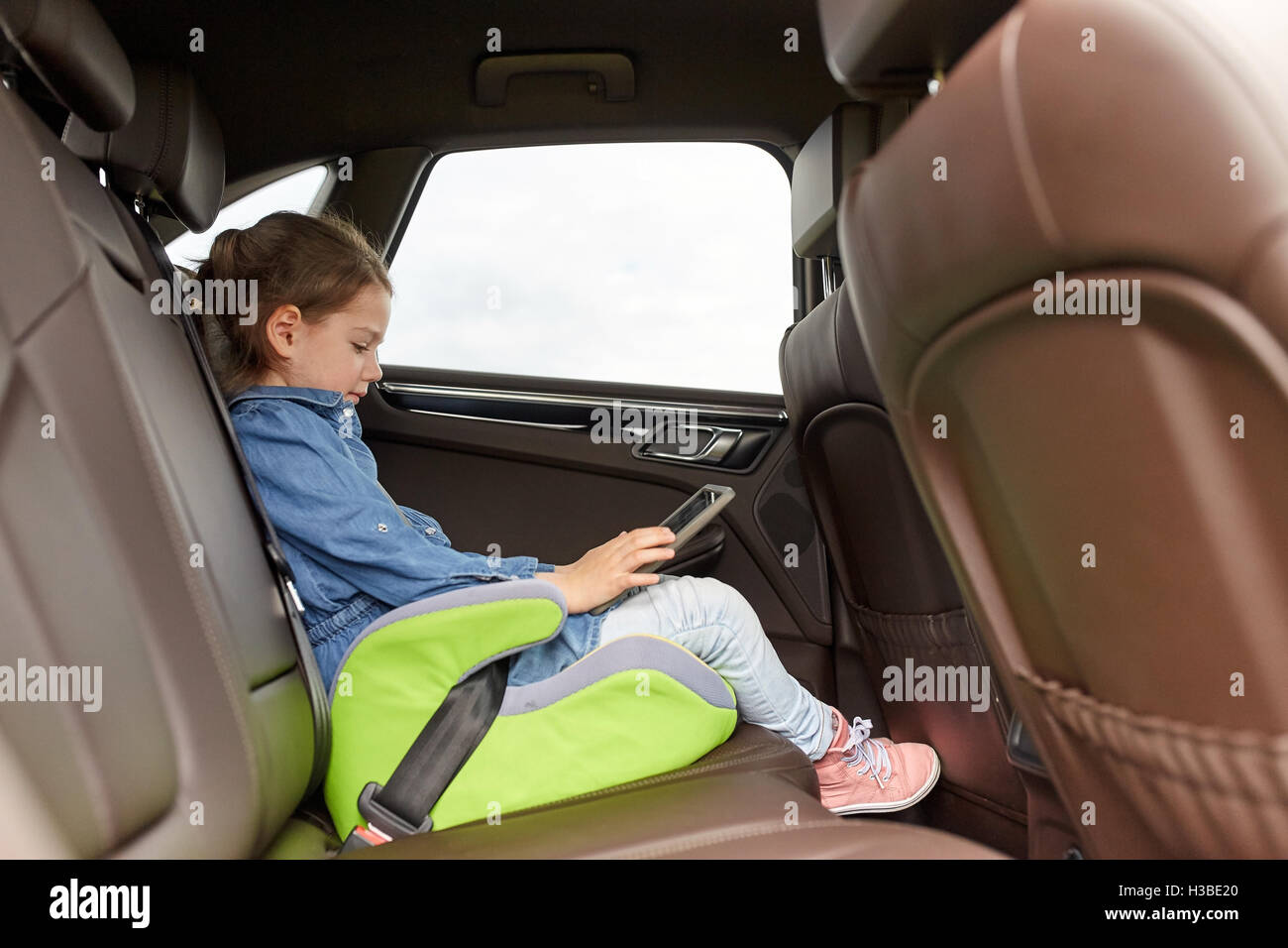 happy little girl with tablet pc driving in car Stock Photo - Alamy