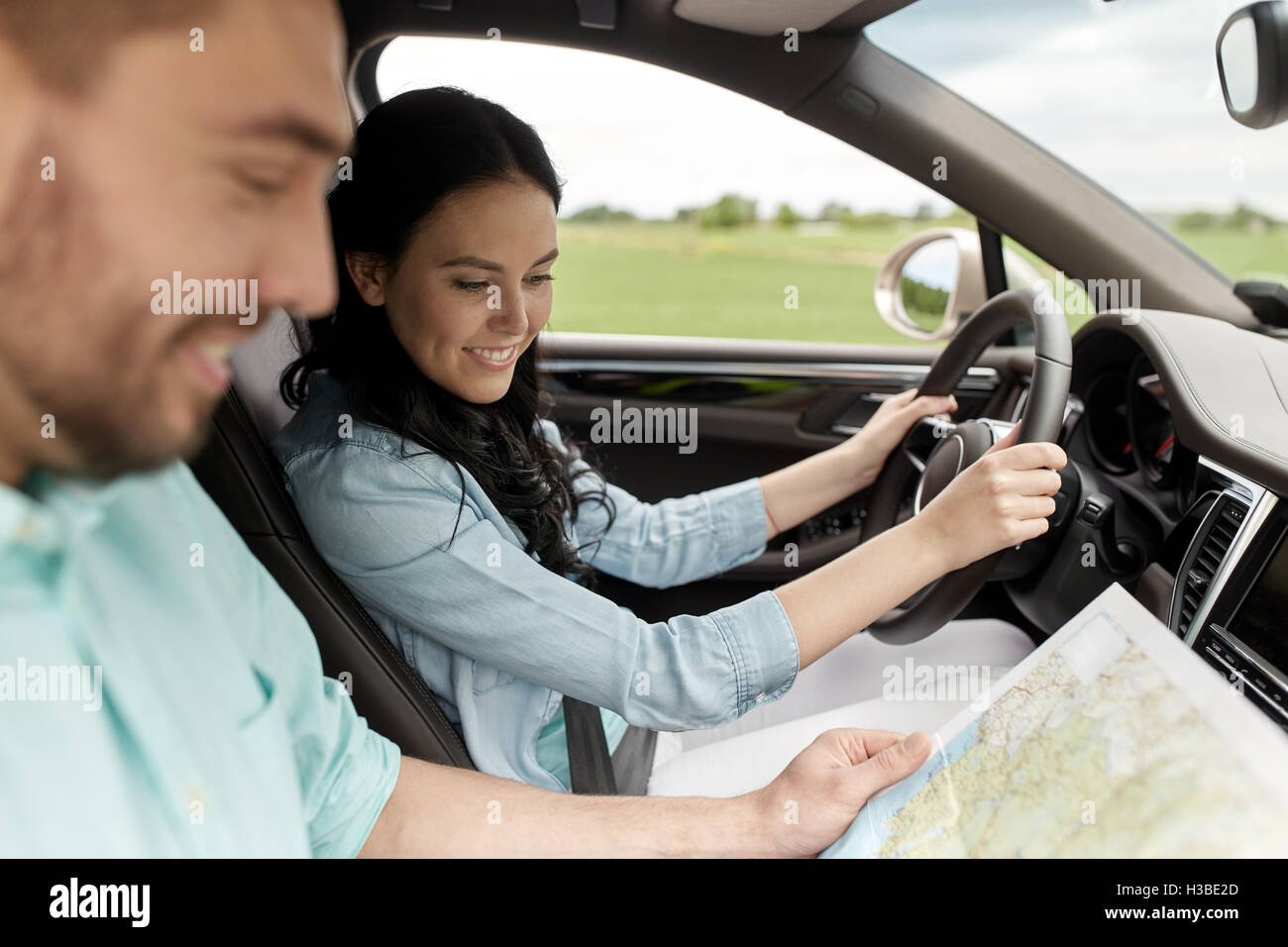 happy man and woman with road map driving in car Stock Photo - Alamy