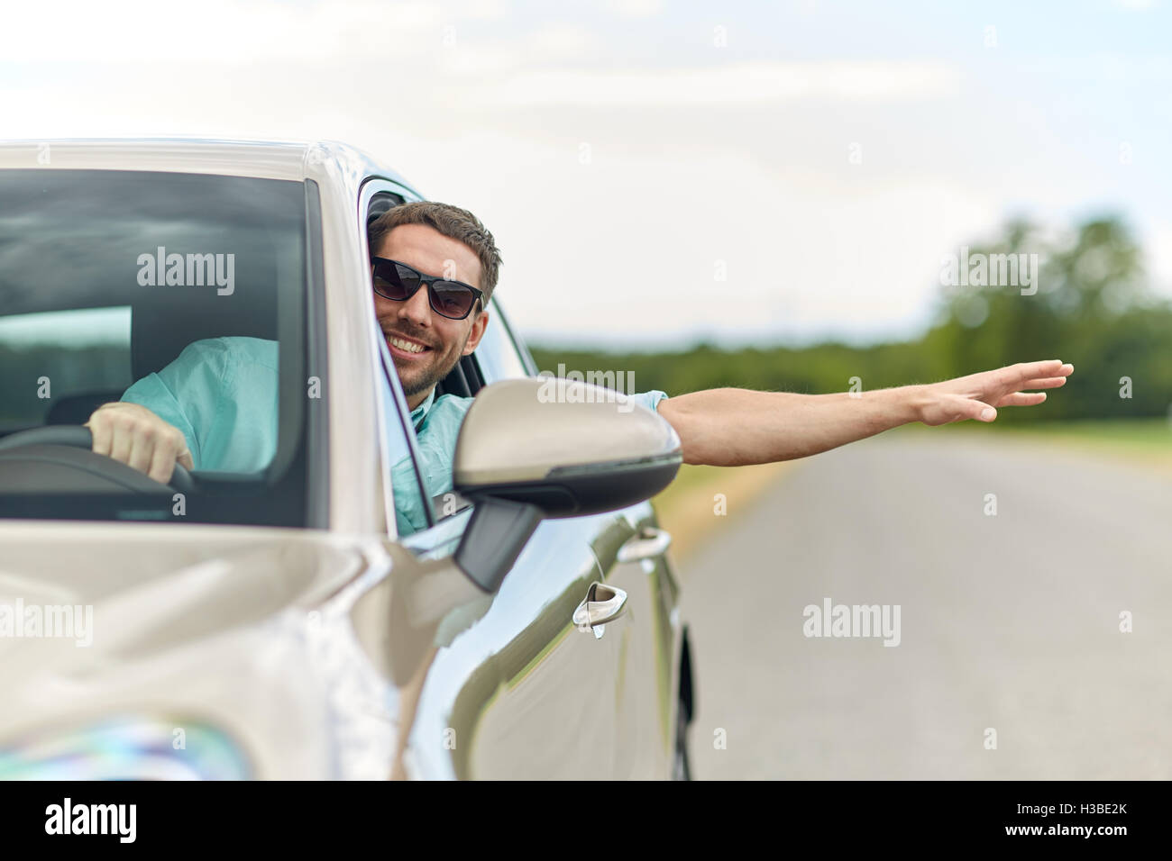 happy man in shades driving car and waving hand Stock Photo - Alamy