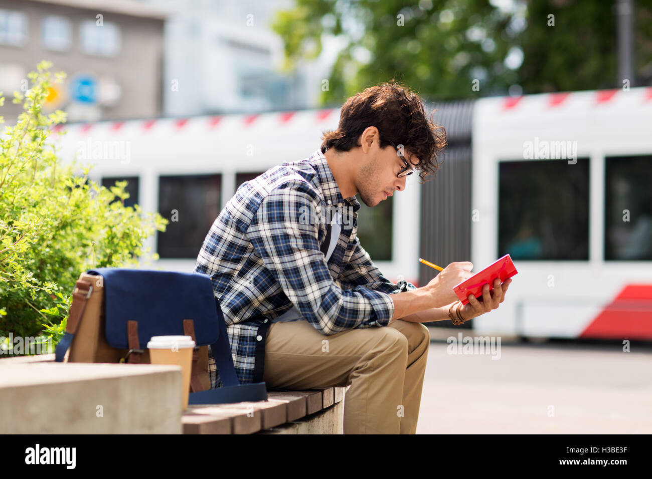 man with notebook or diary writing on city street Stock Photo - Alamy