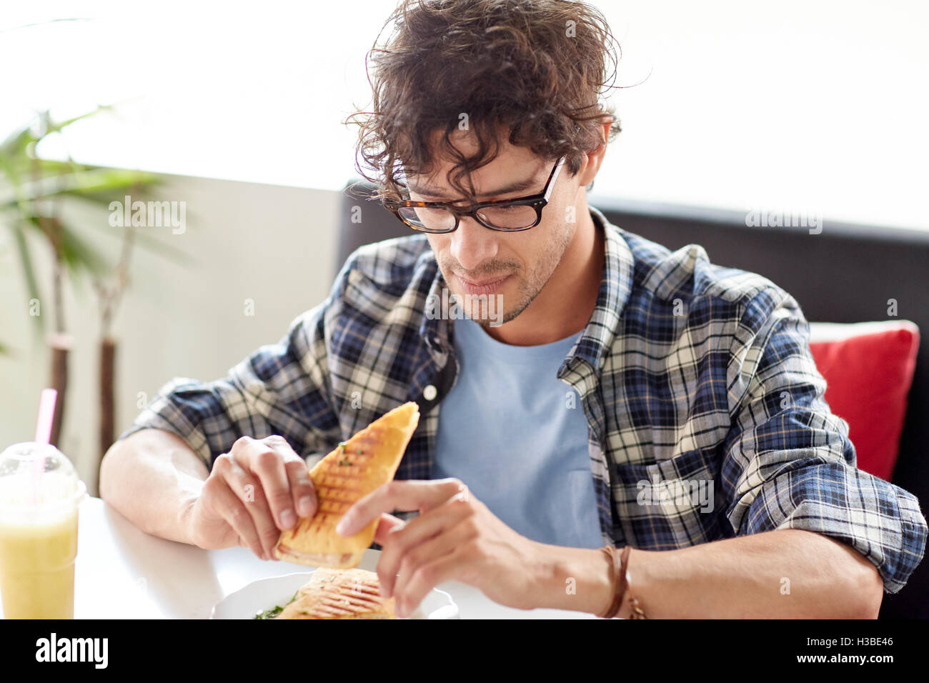 happy man eating sandwich at cafe for lunch Stock Photo - Alamy