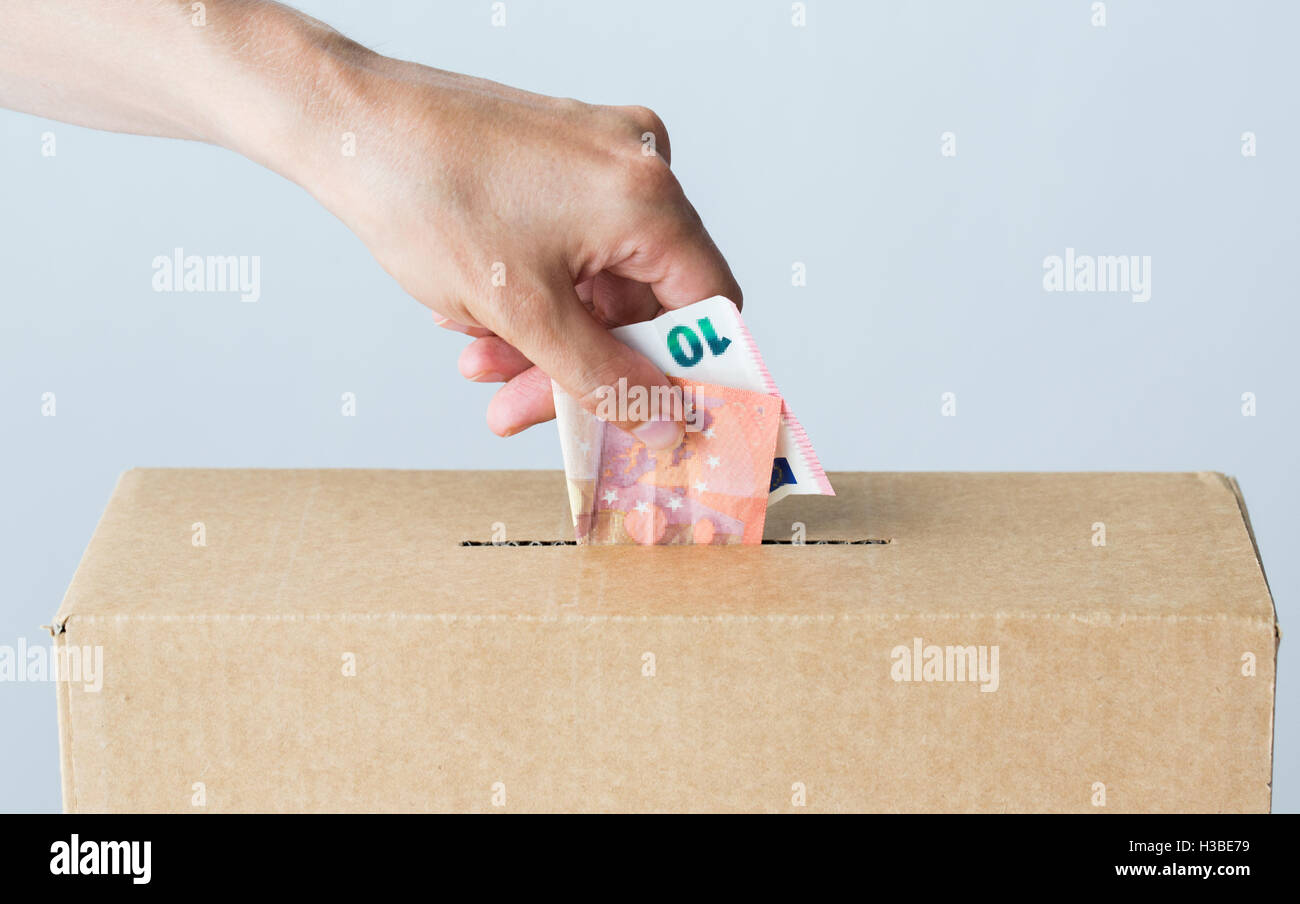 man putting euro money into donation box Stock Photo - Alamy