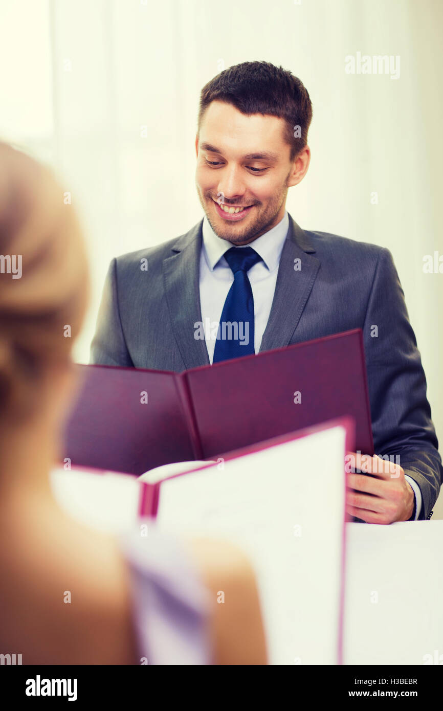 smiling young man looking at menu at restaurant Stock Photo - Alamy