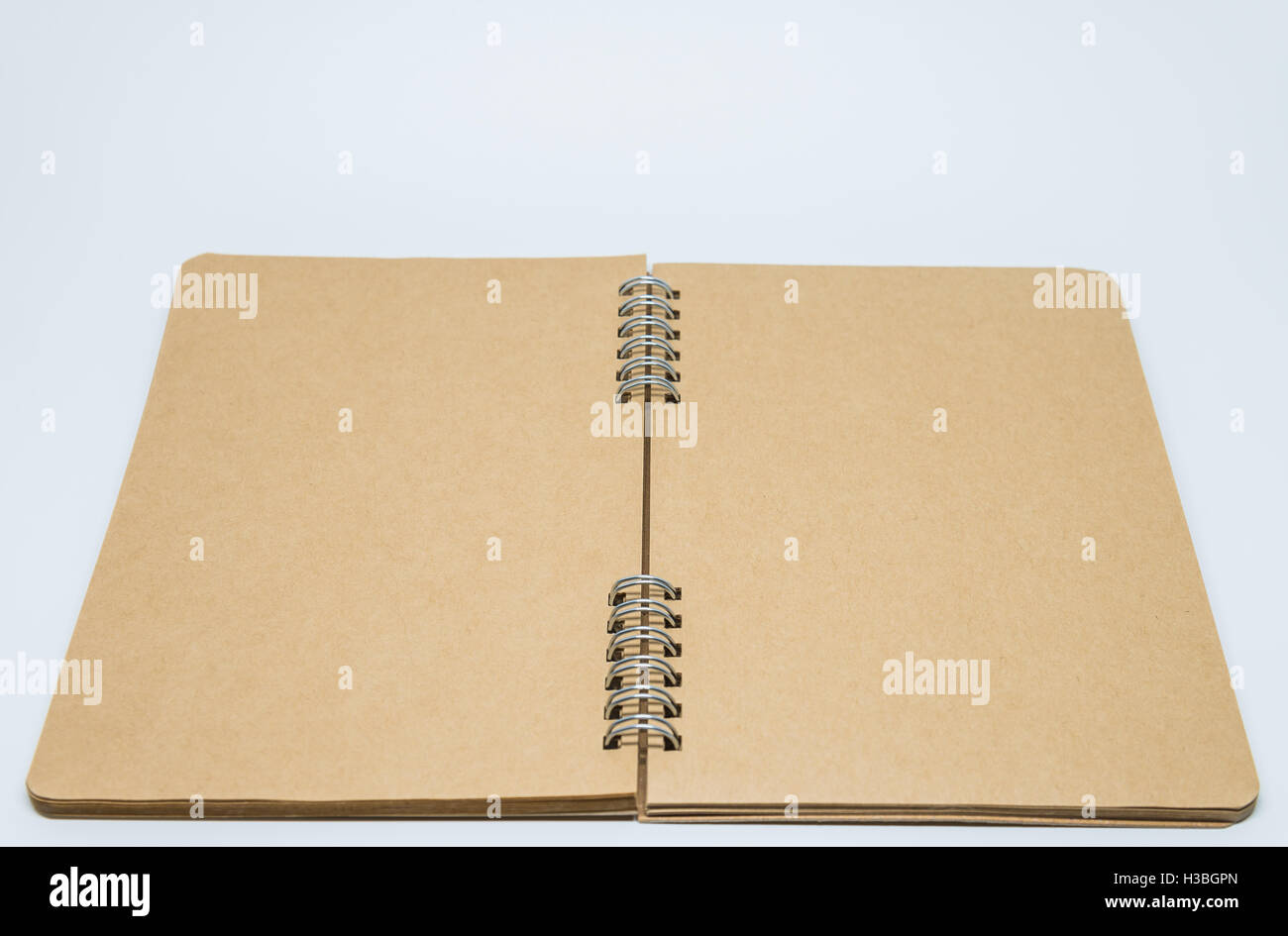 Opened brown plain notebook with white background and selective focus ...