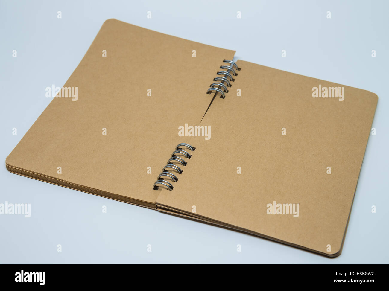 Opened brown plain notebook with white background and selective focus ...