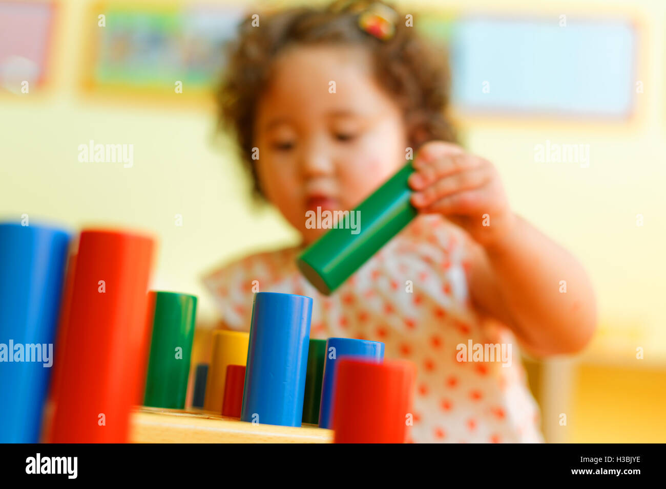 kazakh curly girl playing in kids development center Stock Photo - Alamy