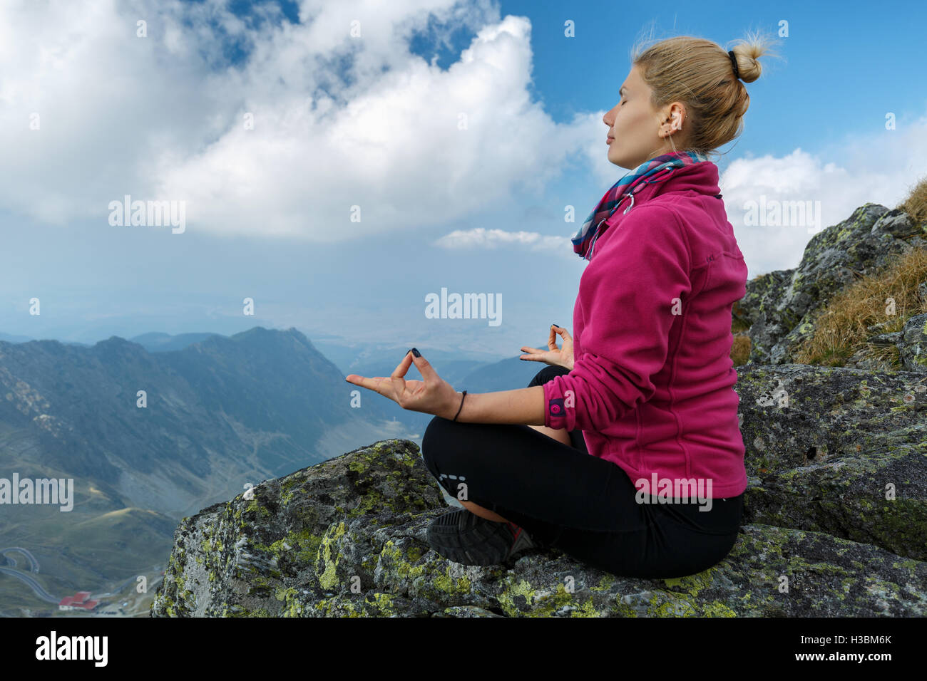 Woman hiker doing yoga meditation on top of the mountain Stock Photo ...