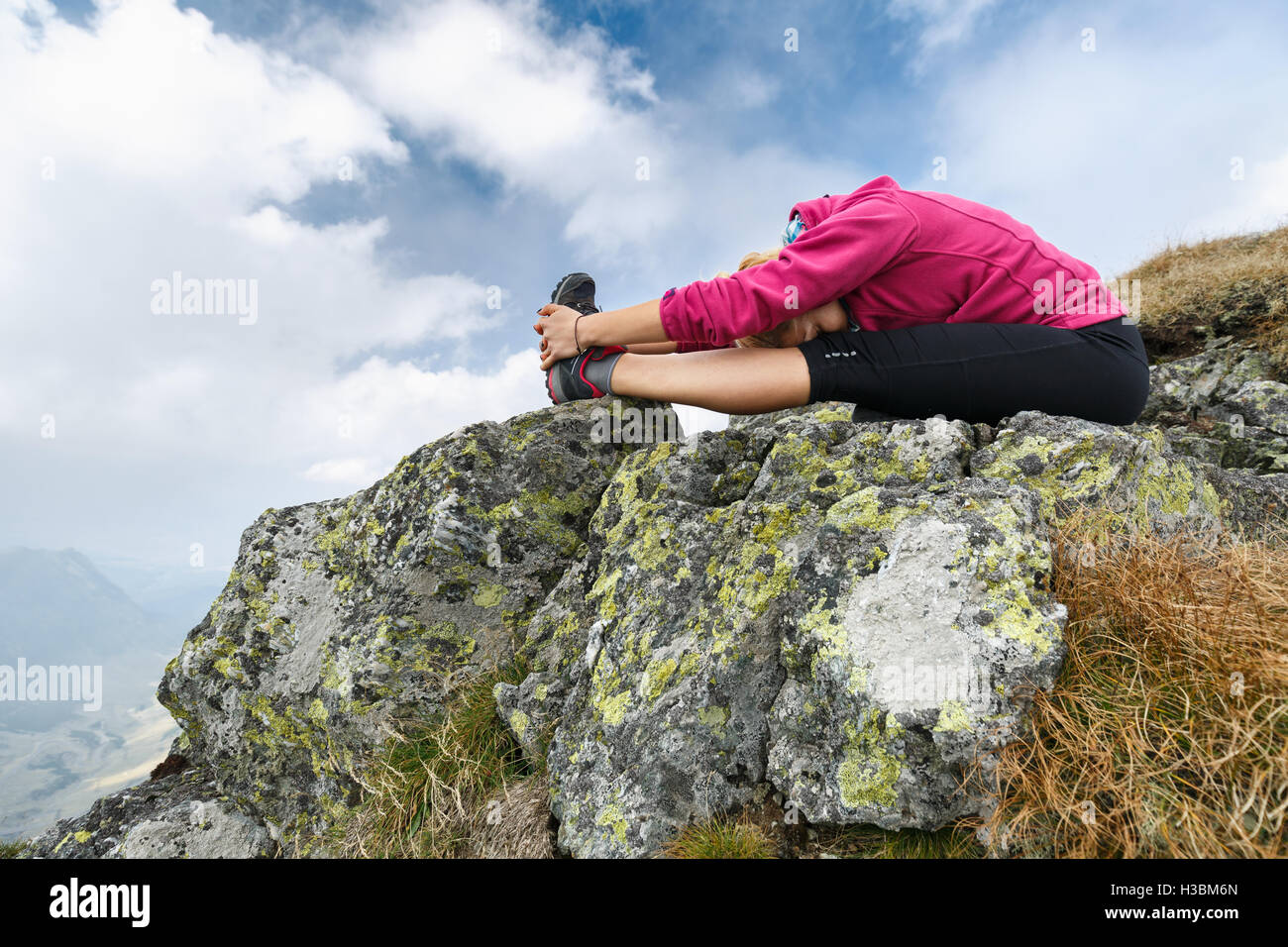 Woman hiker doing yoga meditation on top of the mountain Stock Photo ...