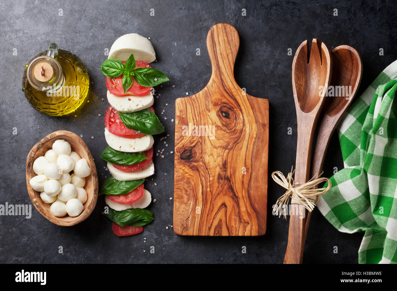 Caprese salad. Mozzarella cheese, tomatoes and basil herb leaves on ...