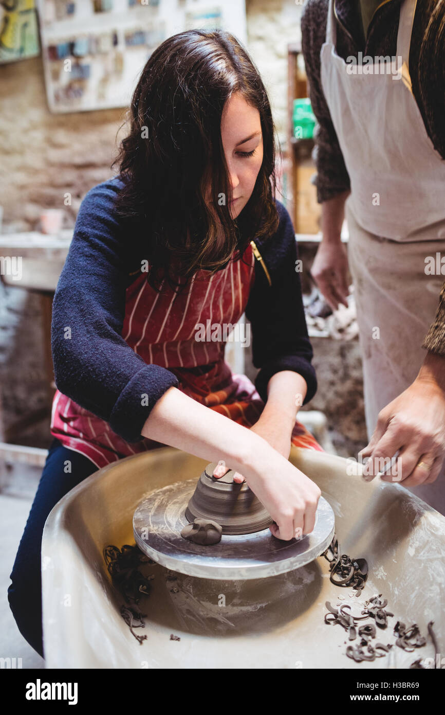 Female potter preparing ceramic container with colleague Stock Photo ...