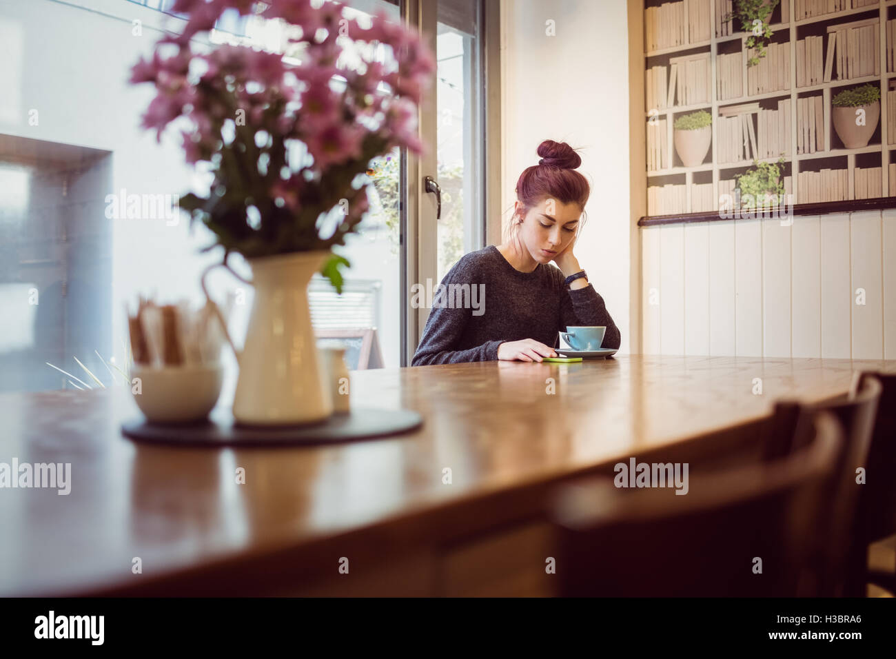 Hipster drinking a cup of coffee while using a smartphone Stock Photo ...