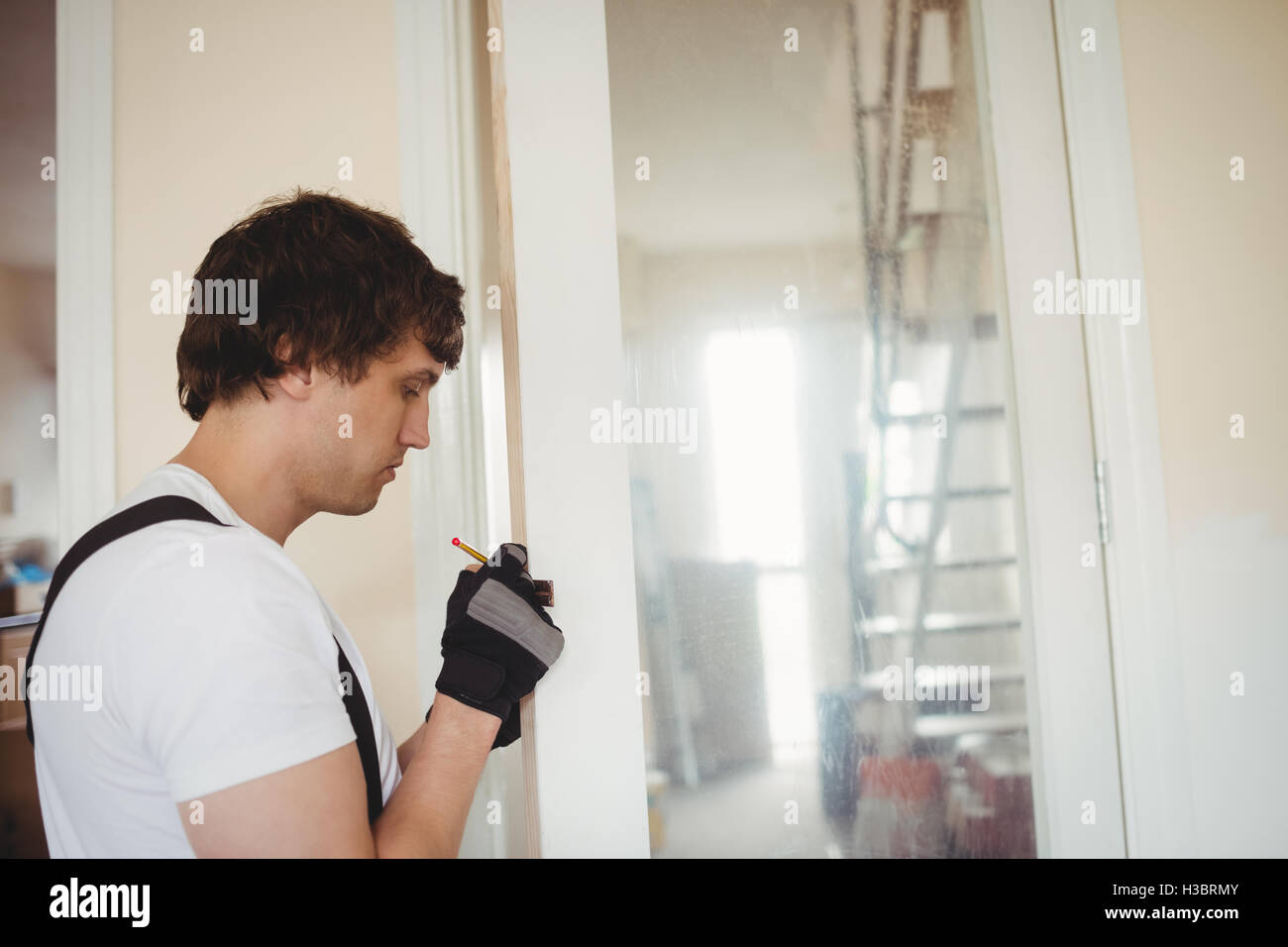 Carpenter measuring a door frame Stock Photo - Alamy