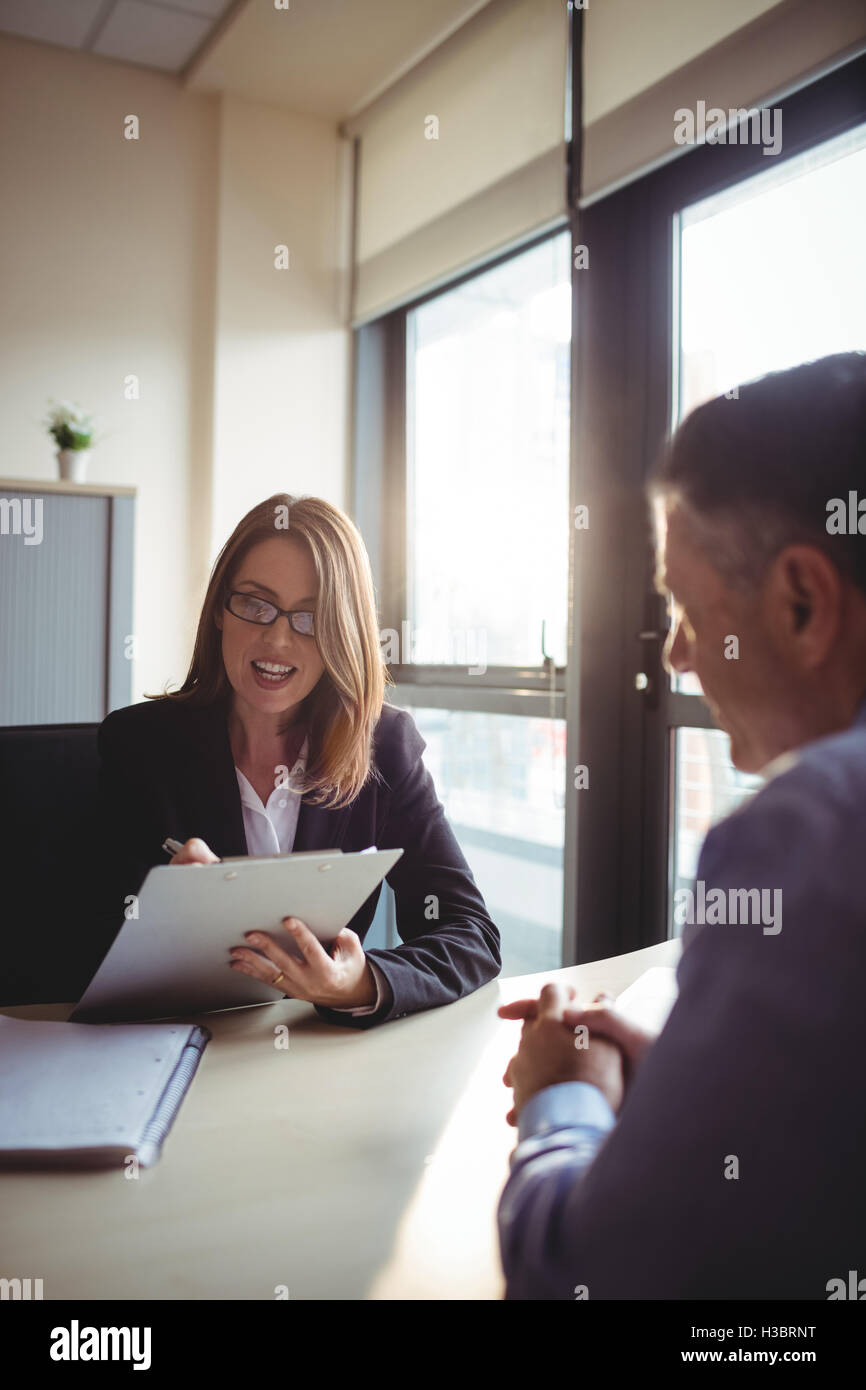 Businesswoman into discussion with colleague Stock Photo - Alamy
