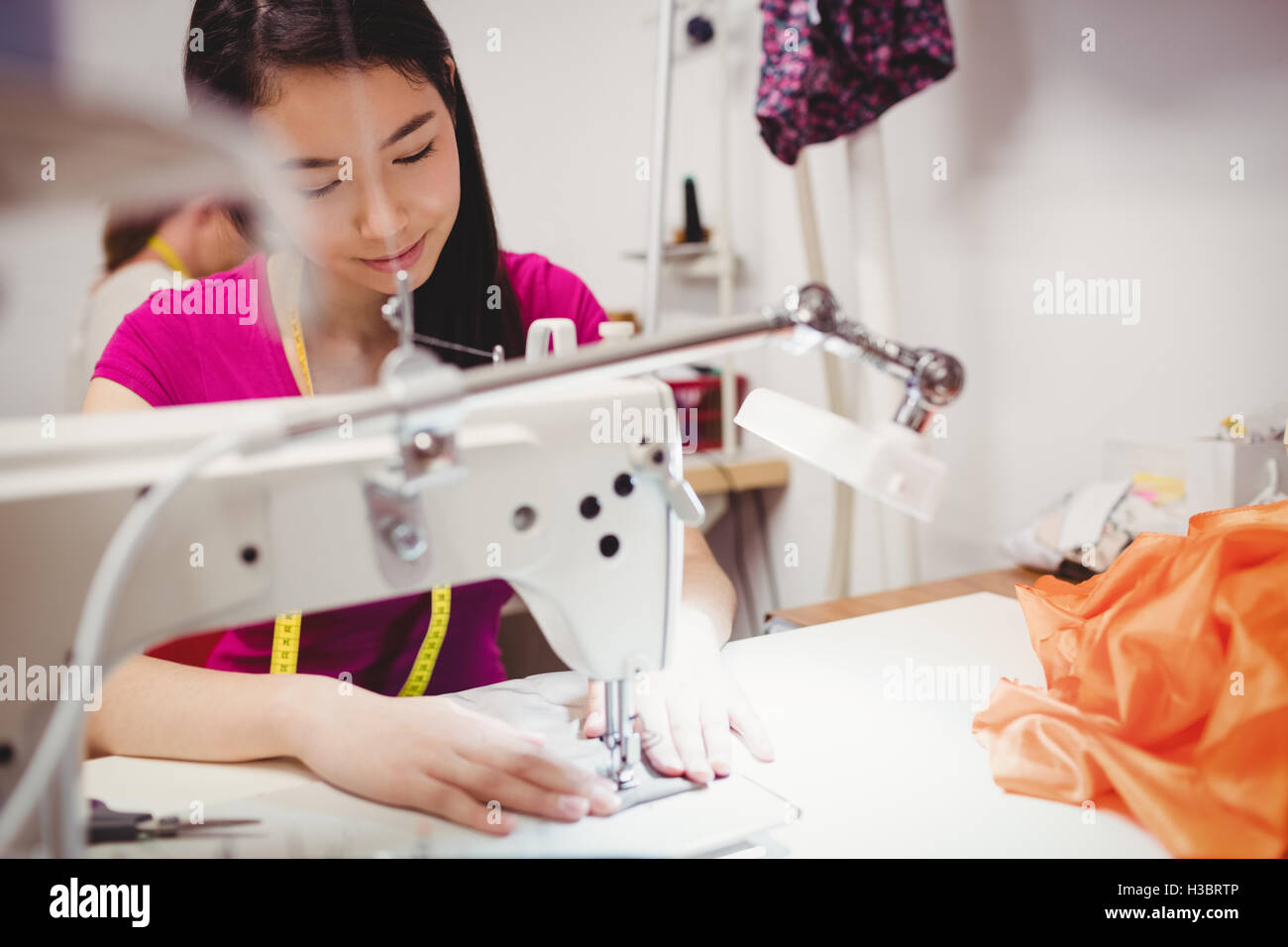 Female dressmaker sewing in the studio Stock Photo - Alamy