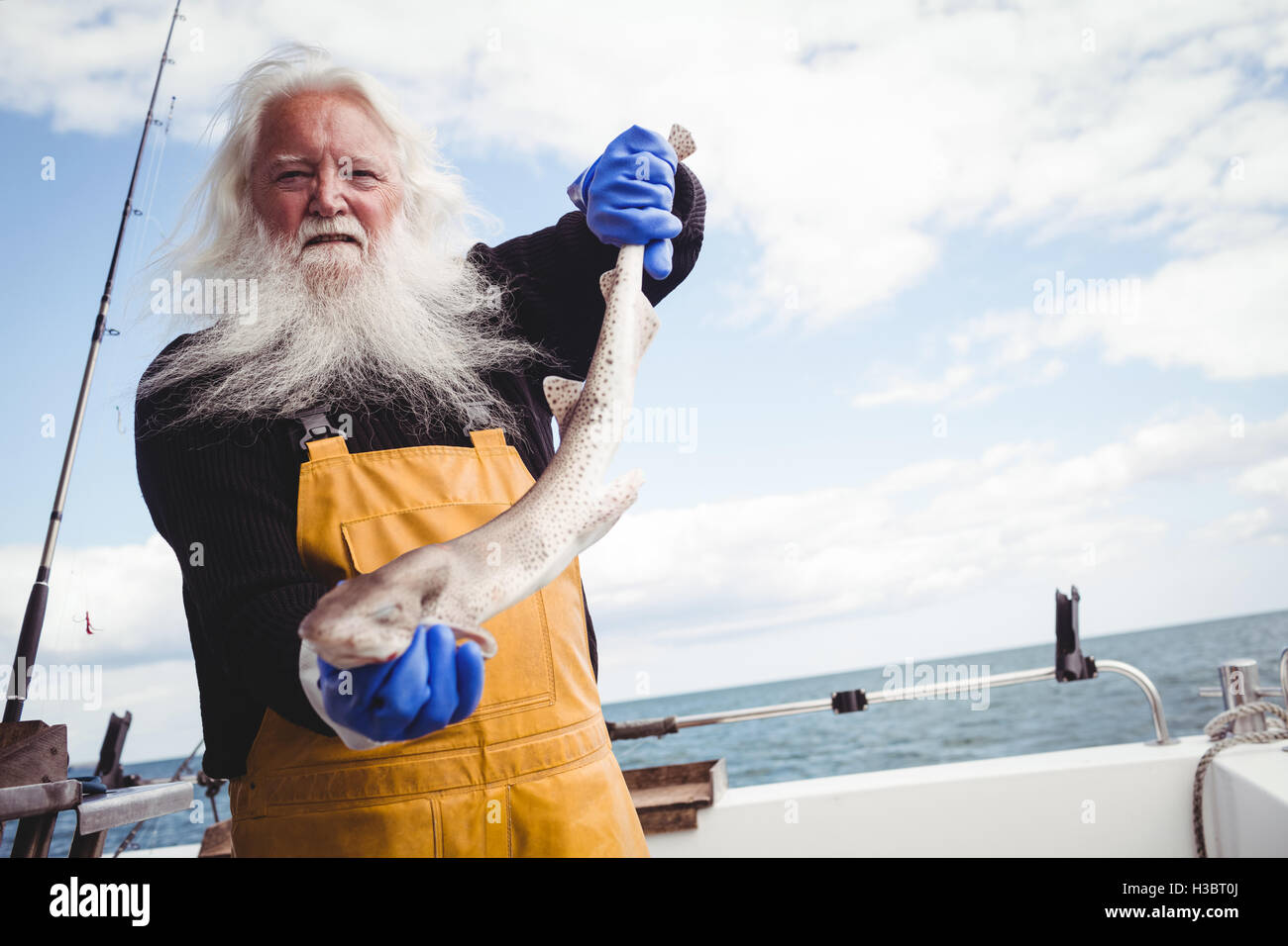 Portrait of fisherman holding fish Stock Photo - Alamy