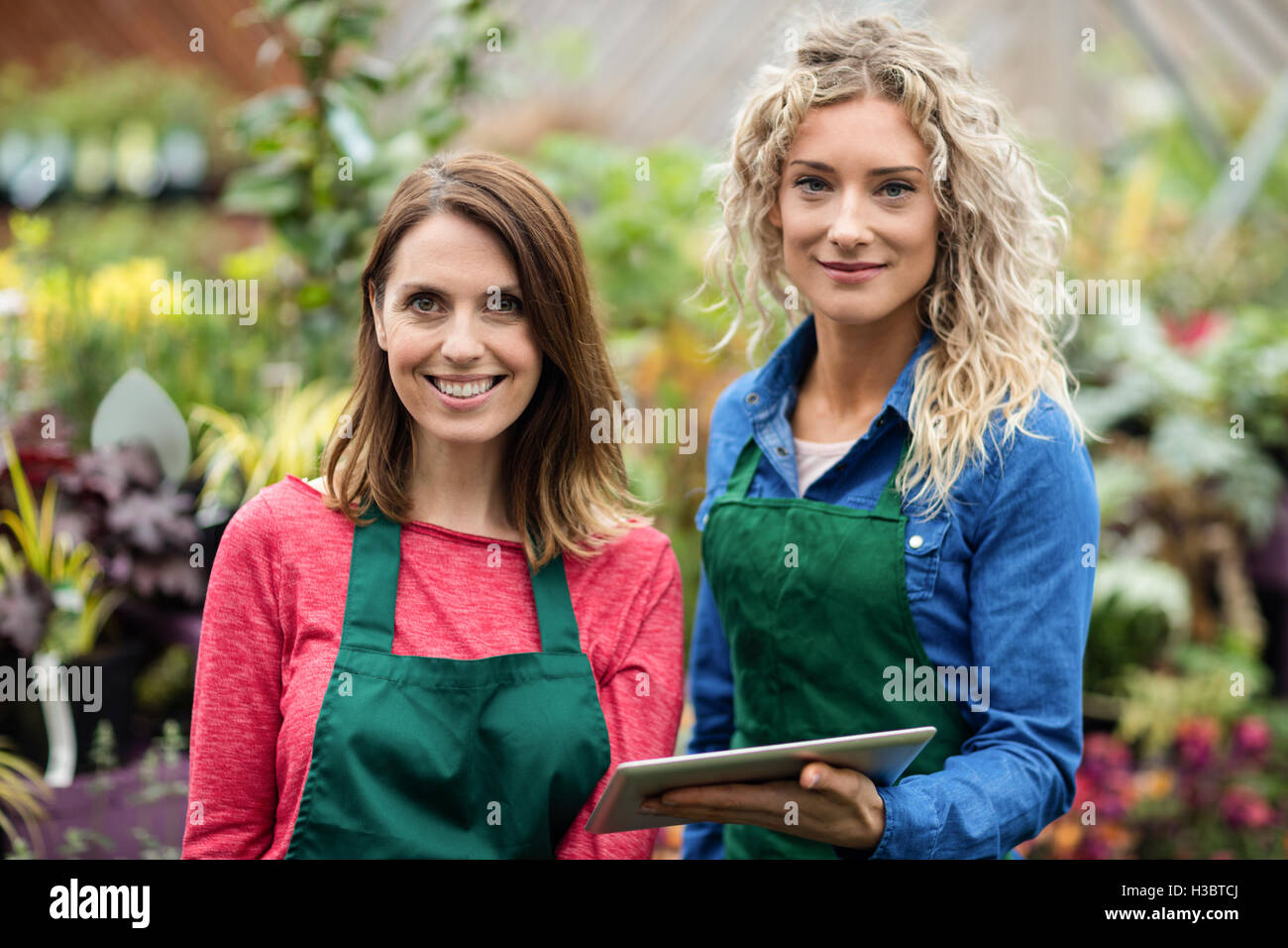 Portrait of two female florist holding digital tablet Stock Photo - Alamy