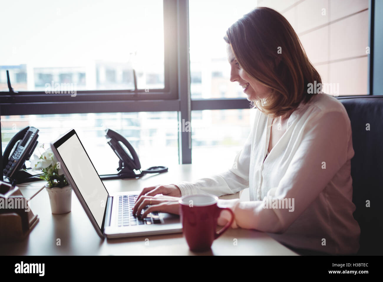 Woman working on laptop Stock Photo - Alamy