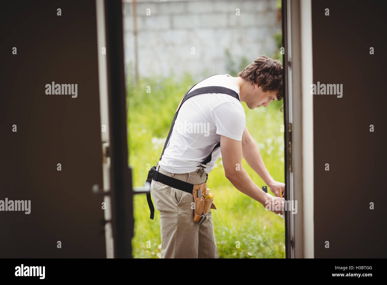 Carpenter measuring a door frame Stock Photo - Alamy