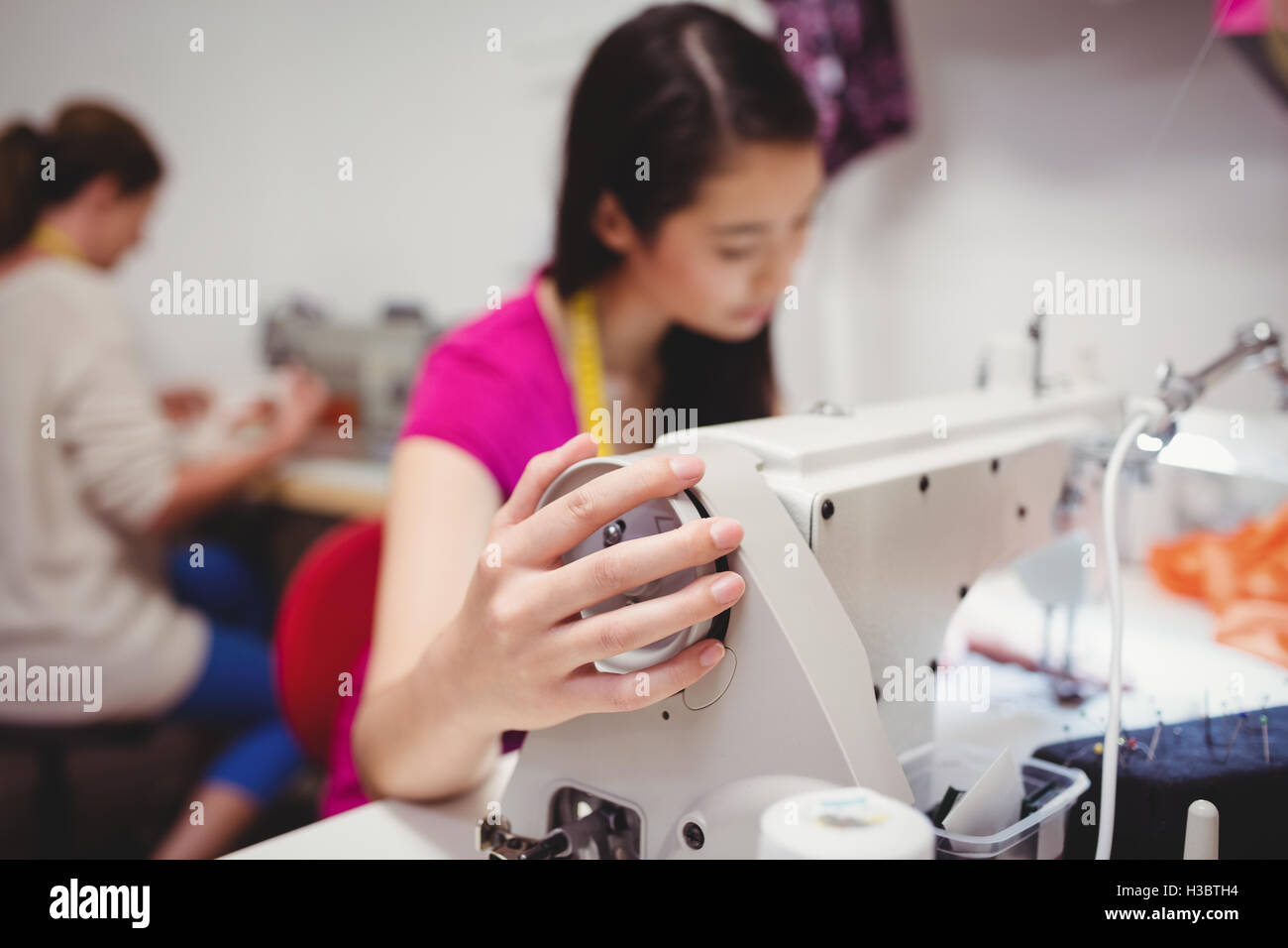 Female dressmaker sewing in the studio Stock Photo - Alamy