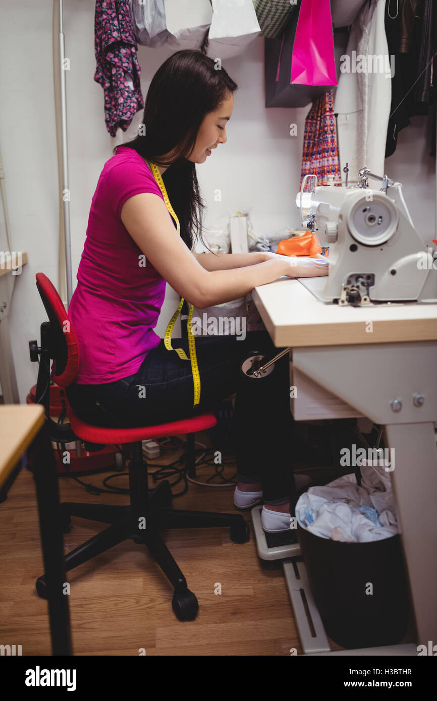 Female dressmaker sewing in the studio Stock Photo - Alamy