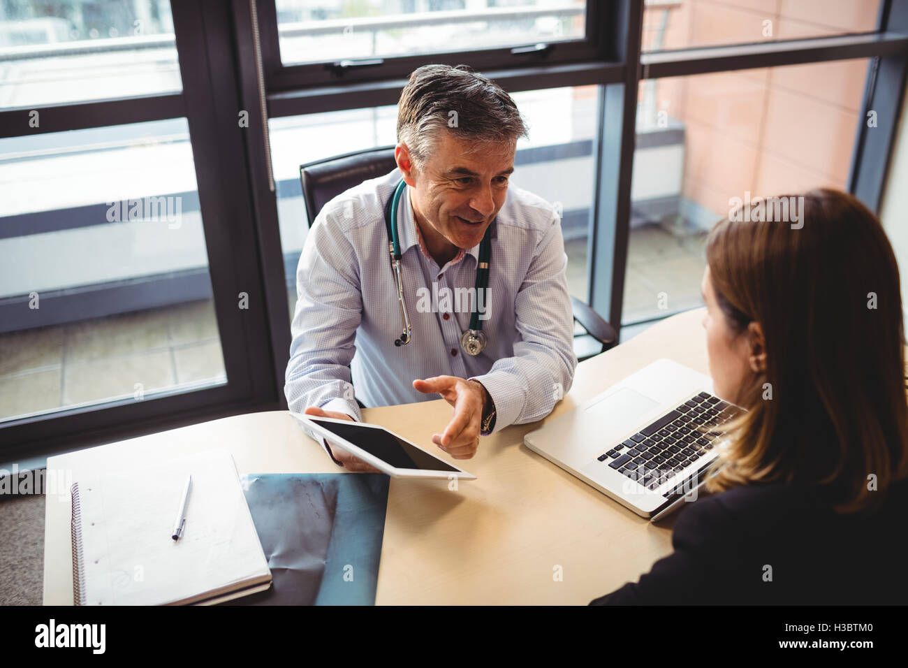 Doctor discussing with patient over digital tablet Stock Photo - Alamy