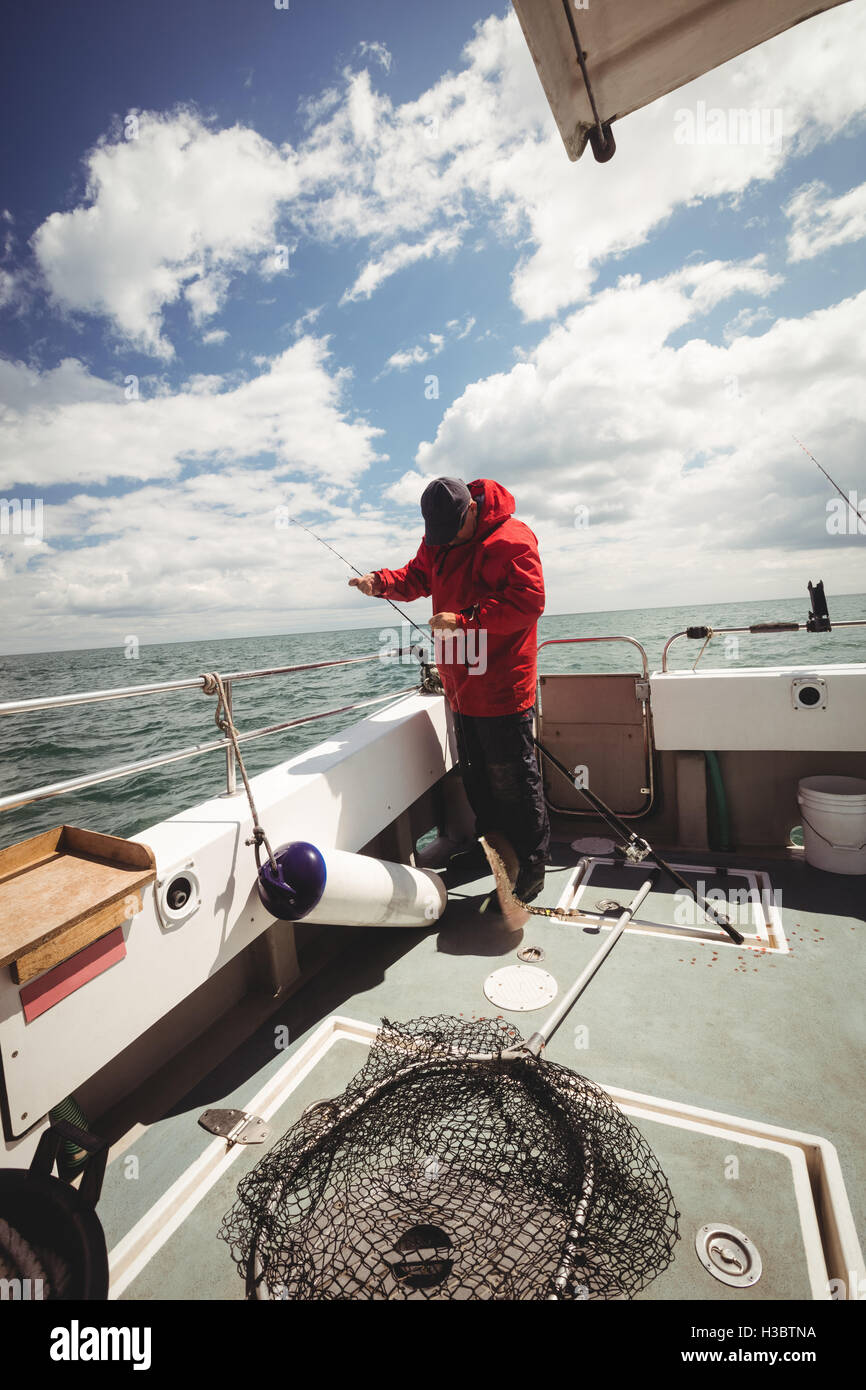 Fisherman fishing from the boat Stock Photo - Alamy